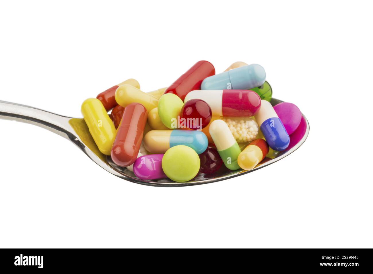 Many colourful tablets on a spoon. Symbolic photo for tablet addiction ...