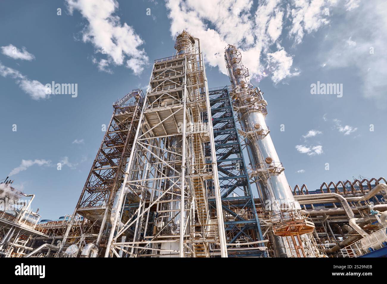 View of a chemical plant featuring a tall distillation column under a ...