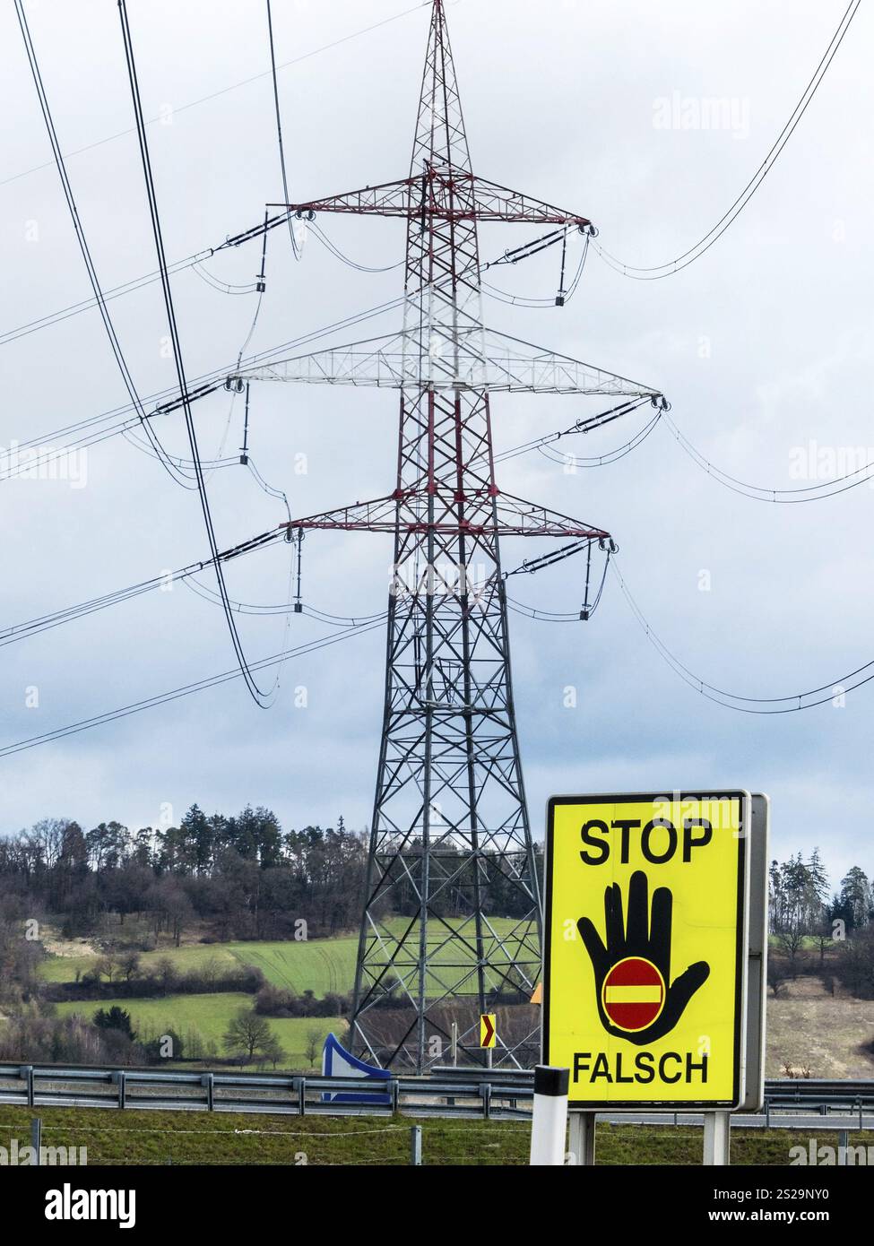 A pylon of a power line and a stop sign. Symbolic photo for phasing out ...