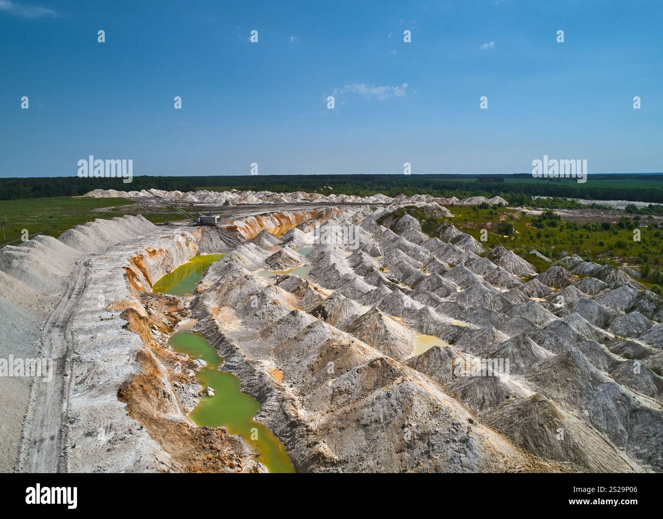 Limestone piles lines and water in trench at mining quarry Stock Photo ...