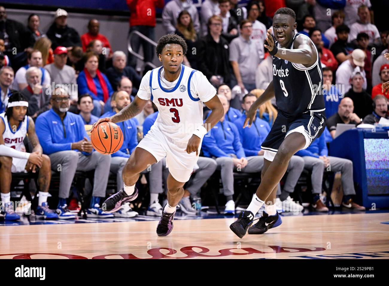 SMU guard Chuck Harris (3) drives to the basket past Duke center Khaman ...