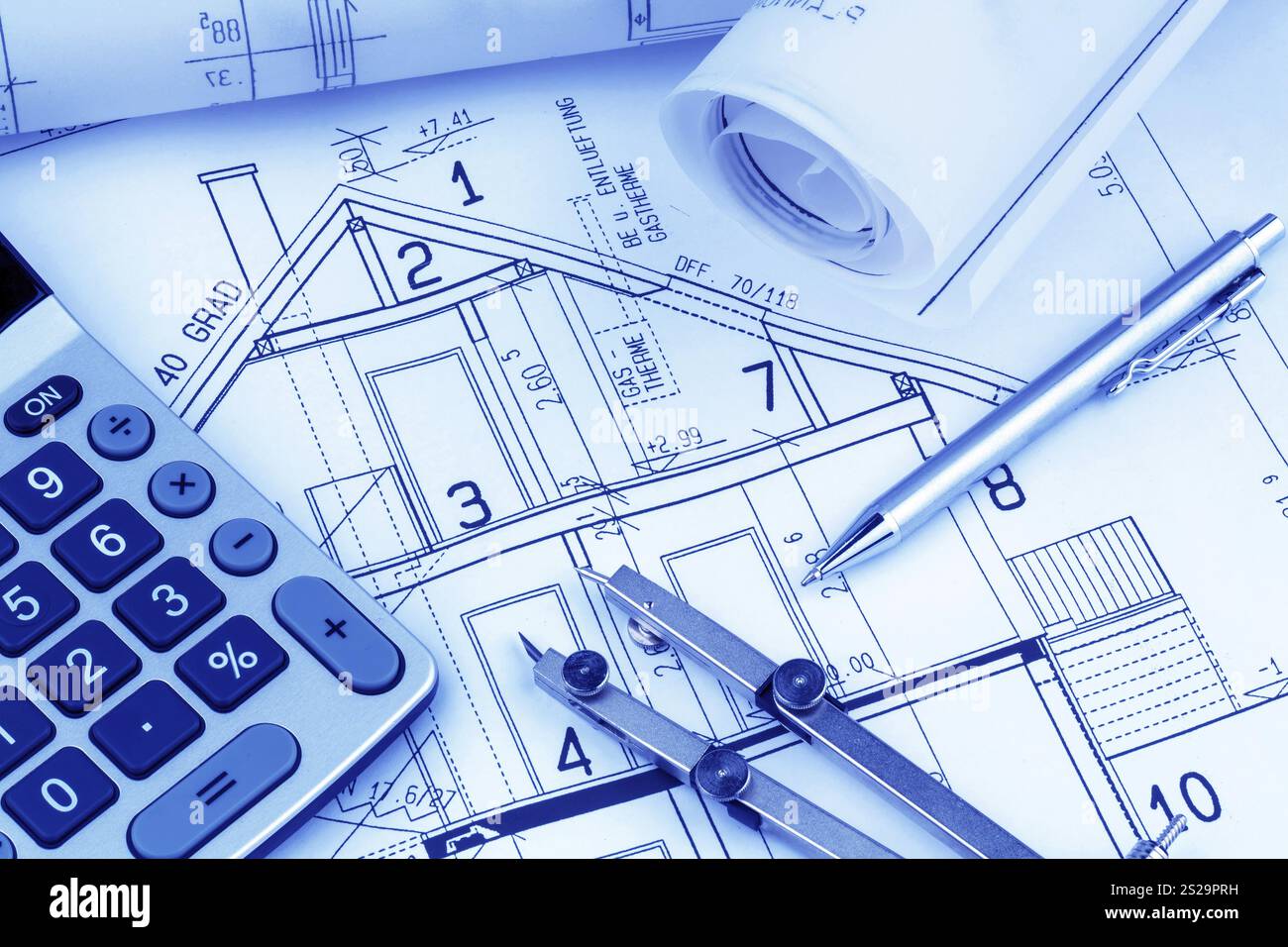 An architect's construction plan with a calculator. Symbolic photo for ...