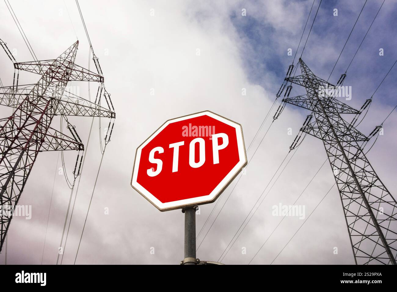 A pylon of a power line and a stop sign. Symbolic photo for phasing out ...