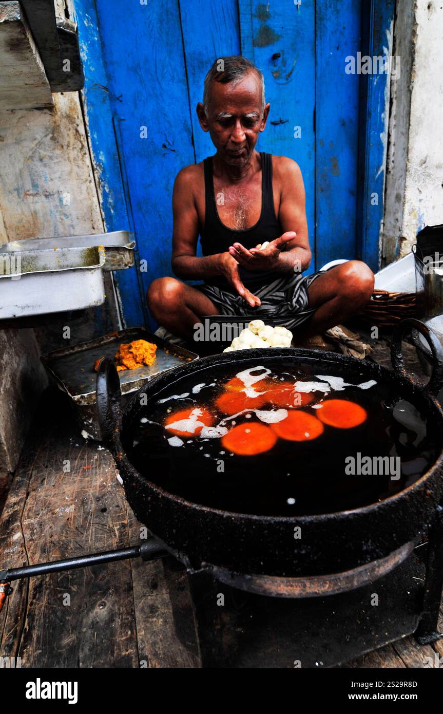 A man deep frying savory snacks on the street in Agra, India Stock ...