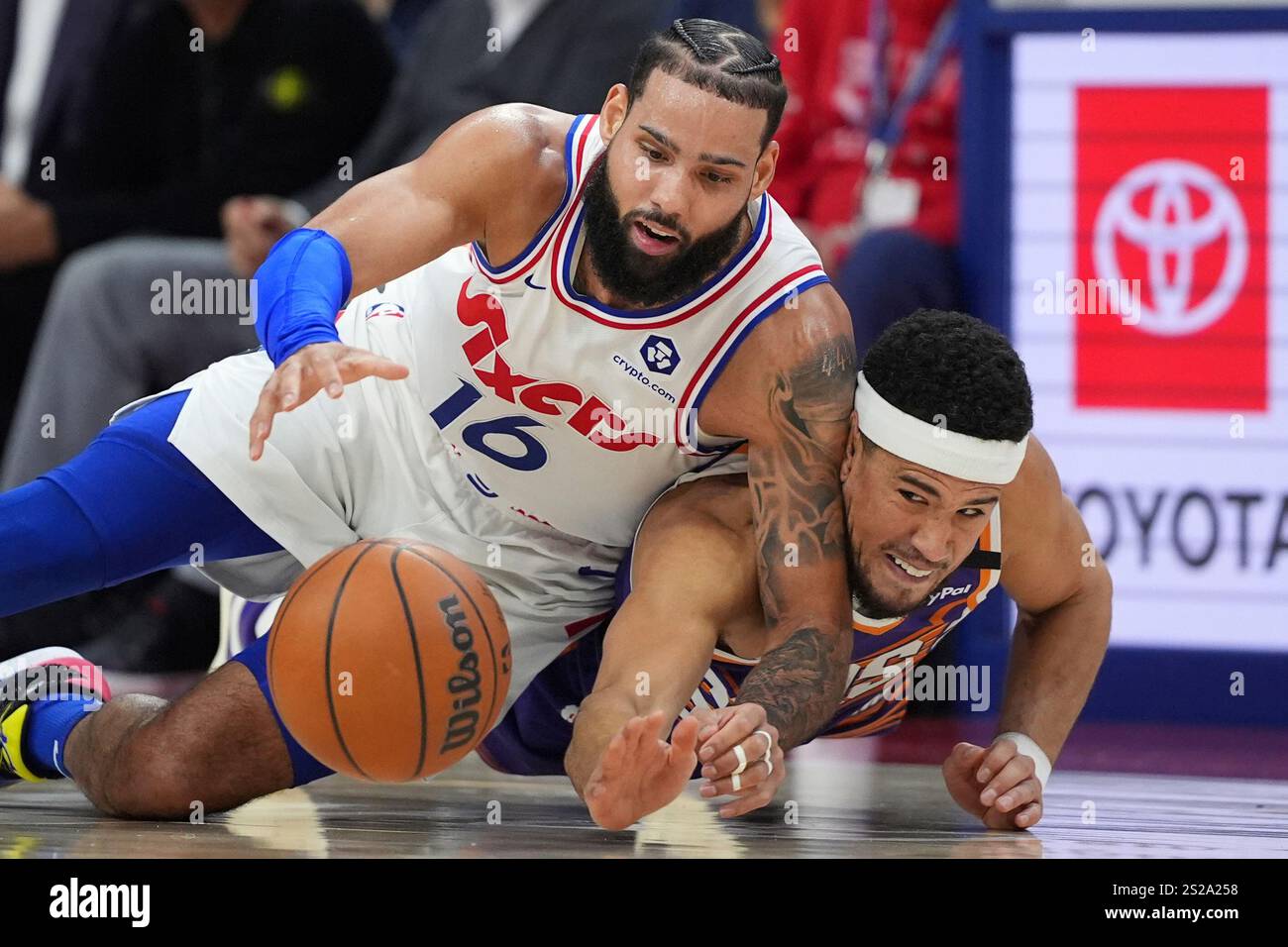Philadelphia 76ers' Caleb Martin, left, and Phoenix Suns' Devin Booker ...