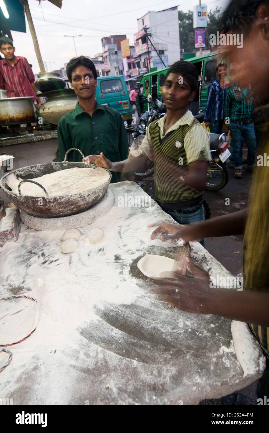 A Man baking roti breads in a tandoor oven in a small bakery at the ...