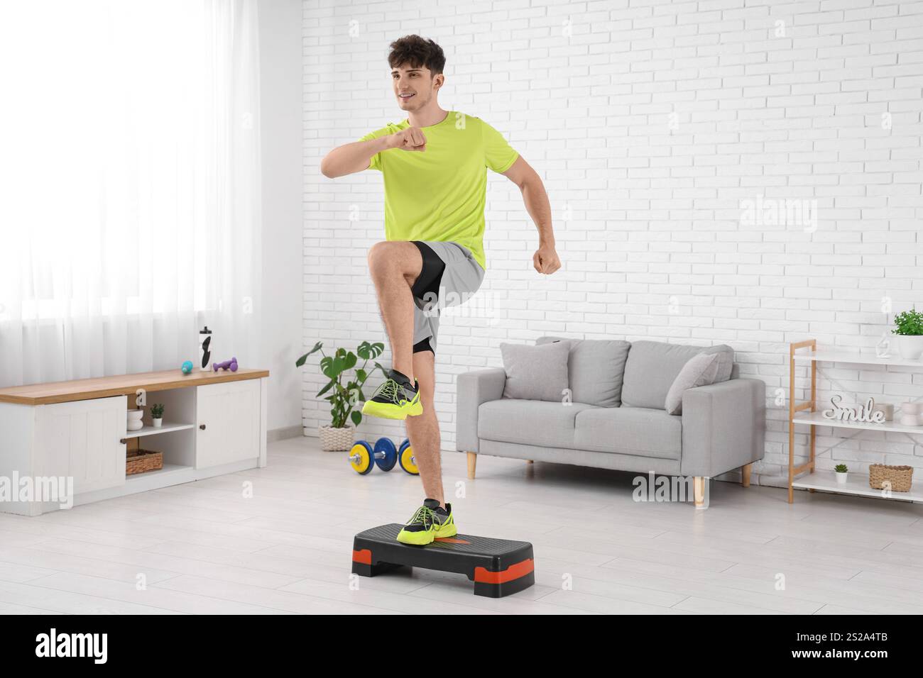 Sporty young man training with stepper at home Stock Photo - Alamy