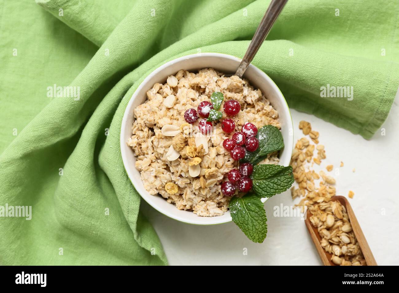 Napkin, bowl with tasty oatmeal and cranberries on white background ...
