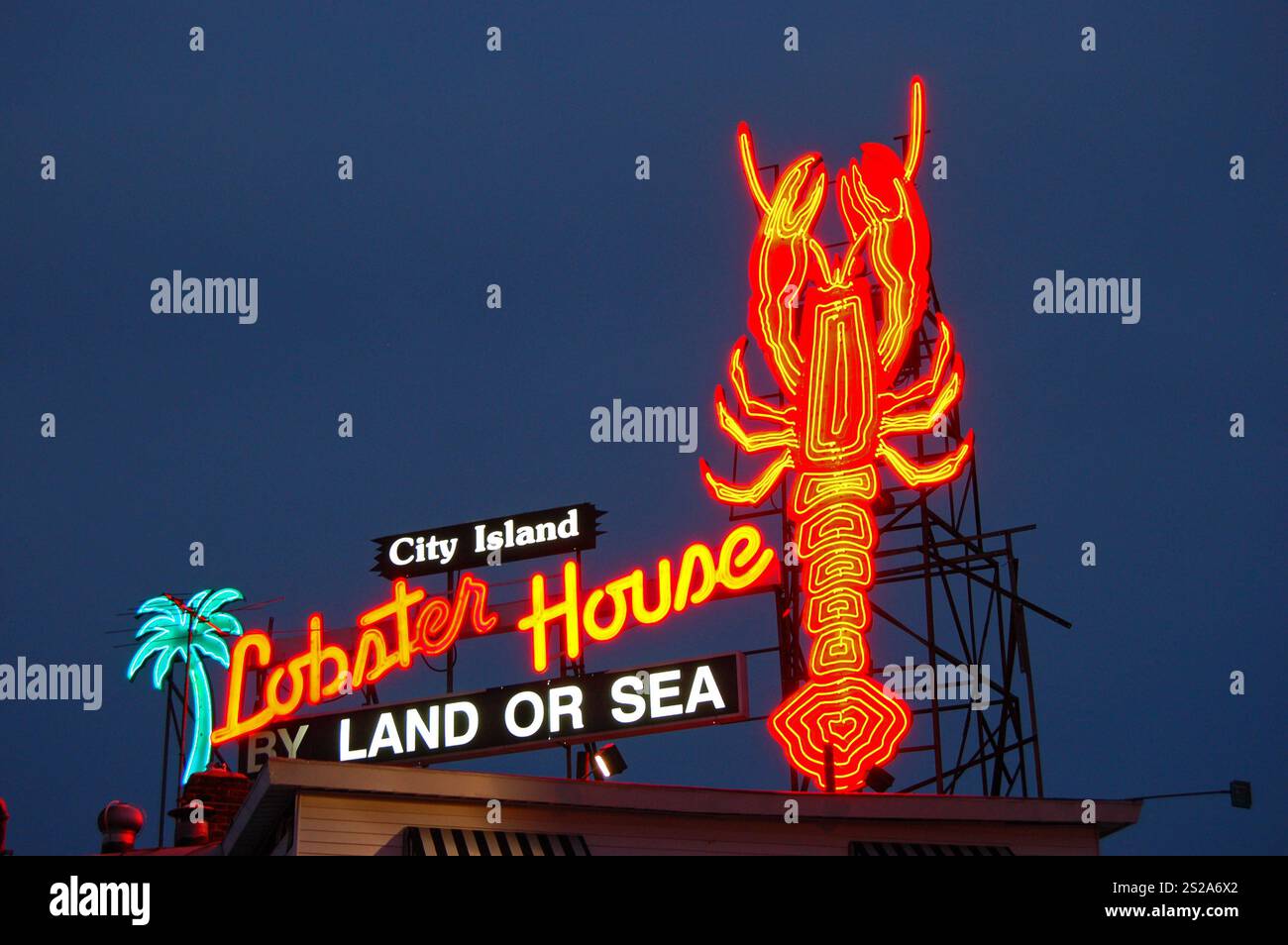 A neon light lobster hangs from the top of a seafood restaurant on City ...