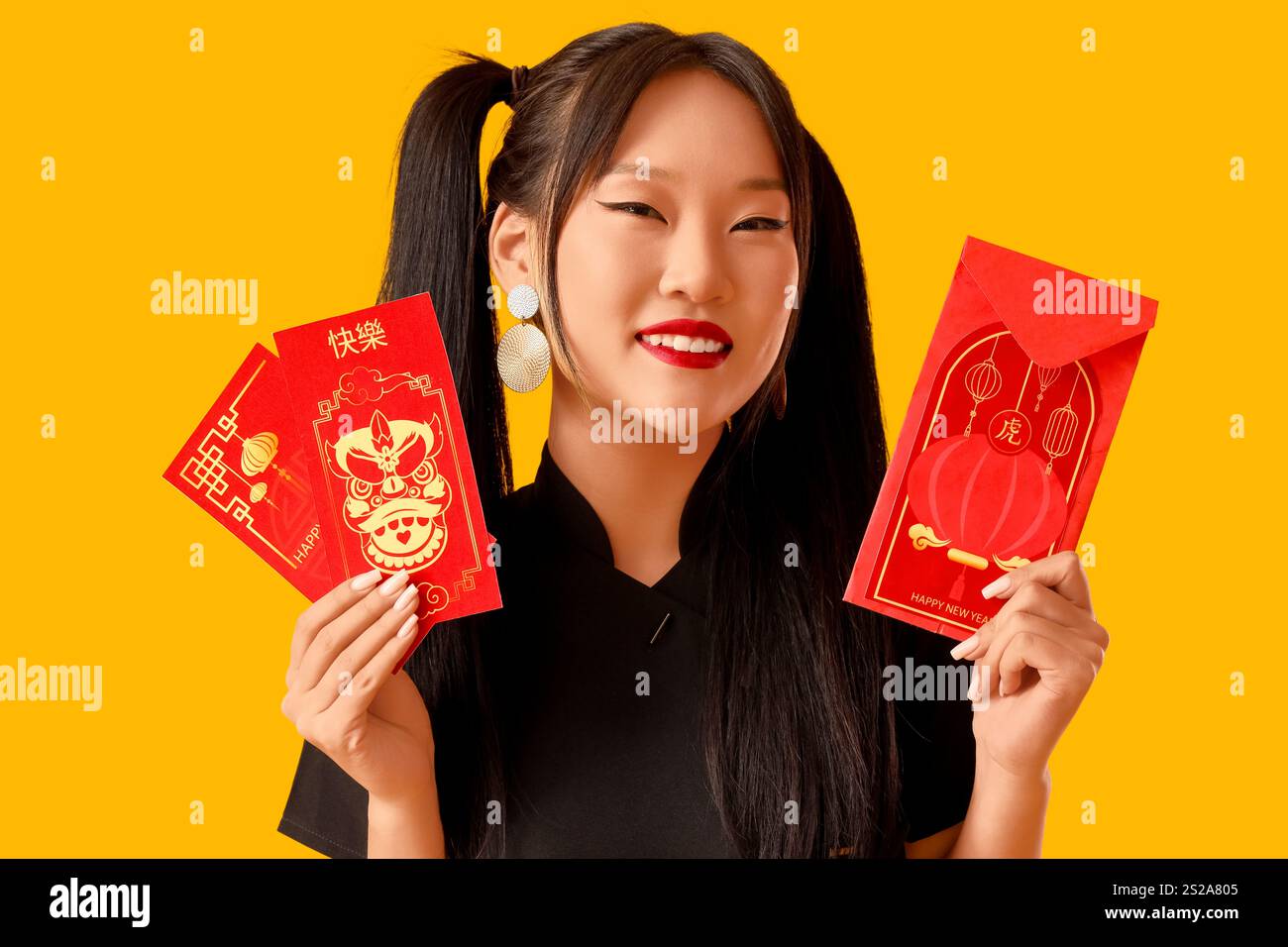 Beautiful Asian woman with Chinese envelopes on yellow background Stock ...