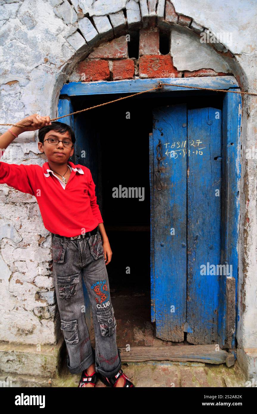 An Indian boy standing outside his home in the old city of Ayodhya ...