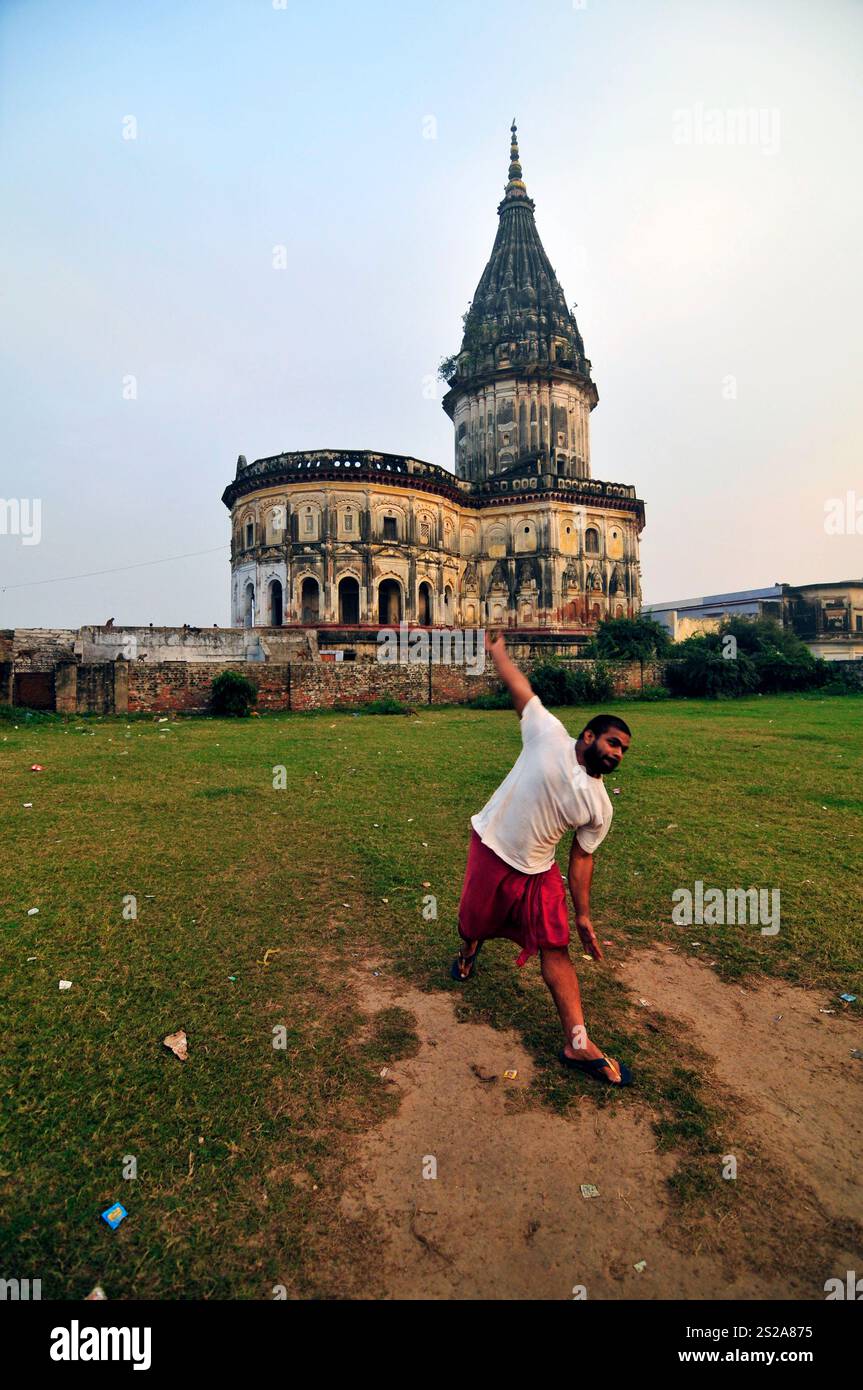 Indian men playing cricket in front of theRaj Dwar Mandir in Ayodhya ...
