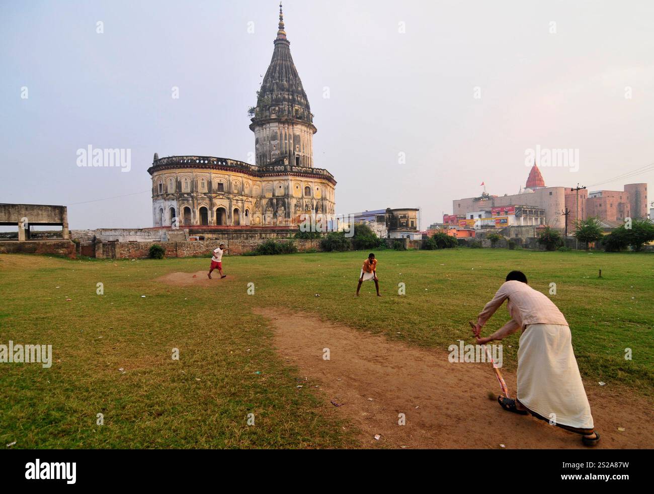 Indian men playing cricket in front of theRaj Dwar Mandir in Ayodhya ...