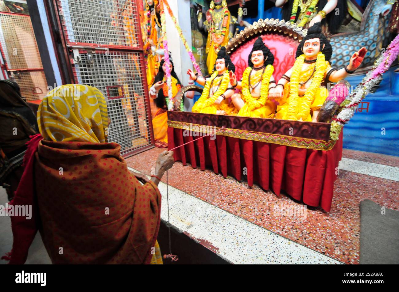 A Hindu pilgrim praying at a small temple dedicated to lord Rama in ...