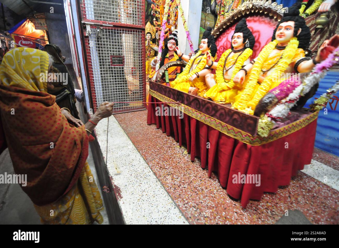 A Hindu pilgrim praying at a small temple dedicated to lord Rama in ...
