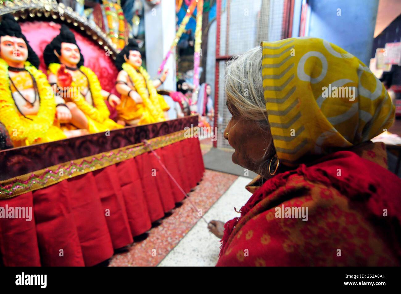 A Hindu pilgrim praying at a small temple dedicated to lord Rama in ...
