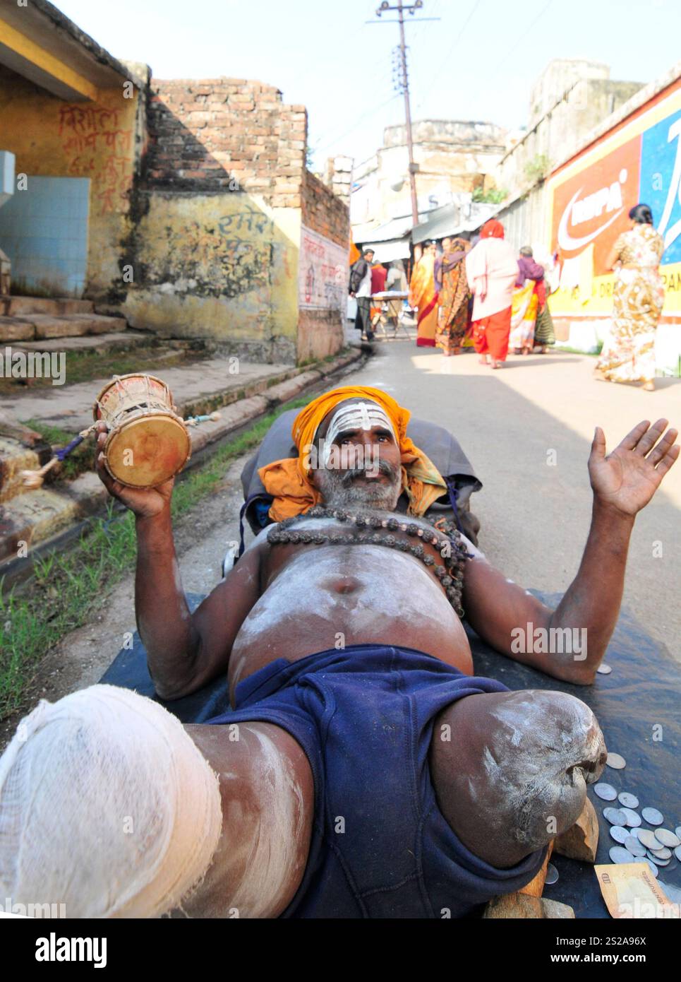 An amputee man playing a percussion instrument and collecting money ...