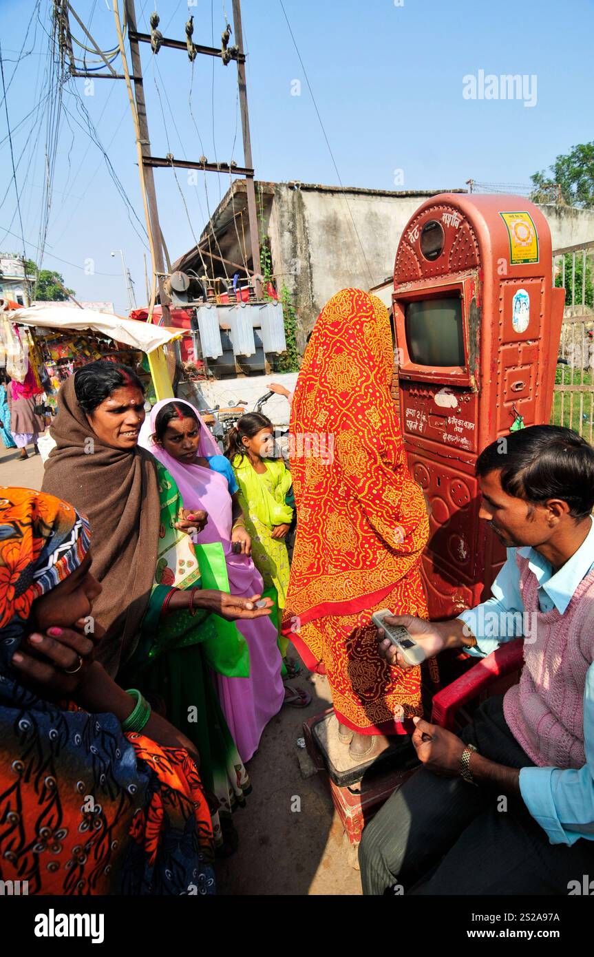 Pilgrims weighing themselves on a scale with an electronic screen ...