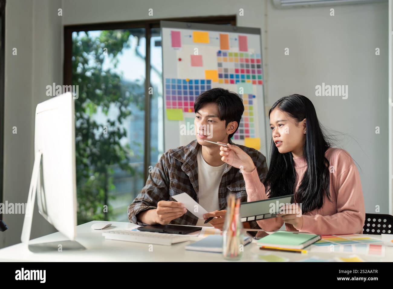 Design team collaborating on graphics project in modern office space fostering creativity and ...