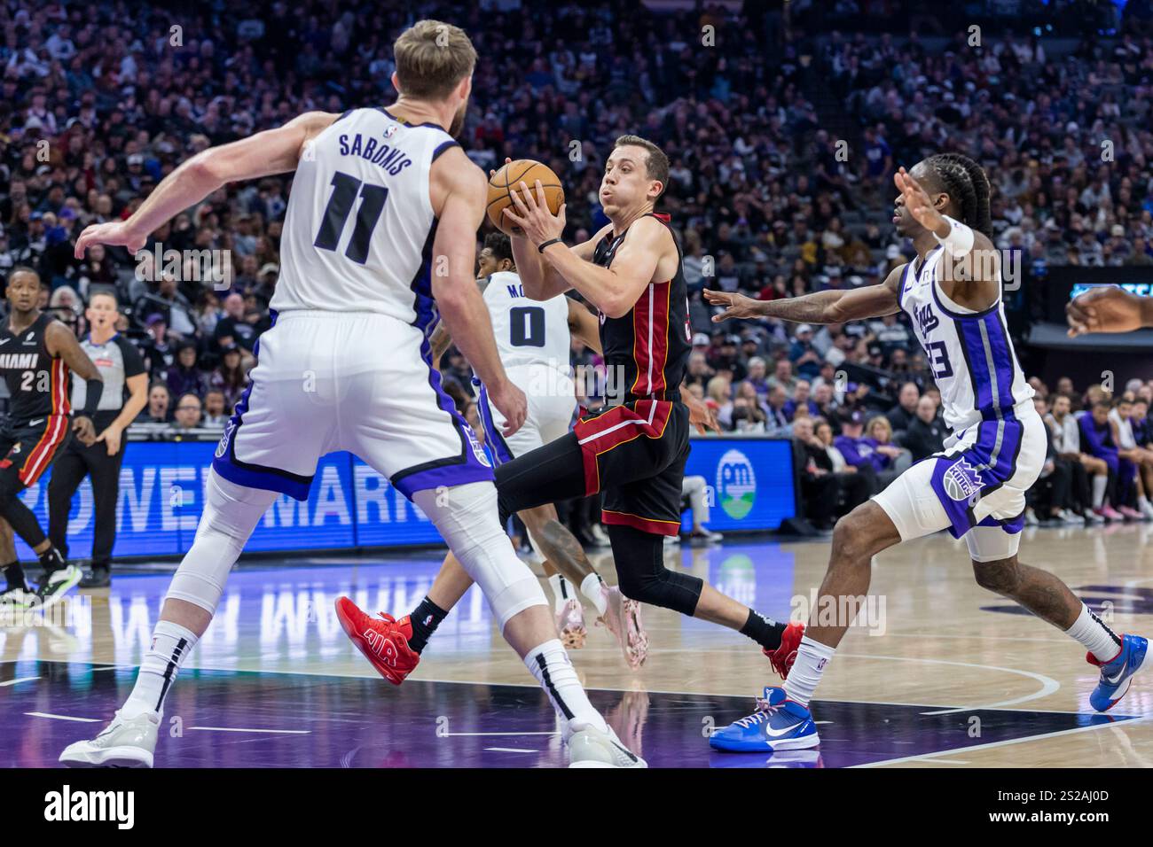 Miami Heat forward Duncan Robinson, center, drives to the basket past ...