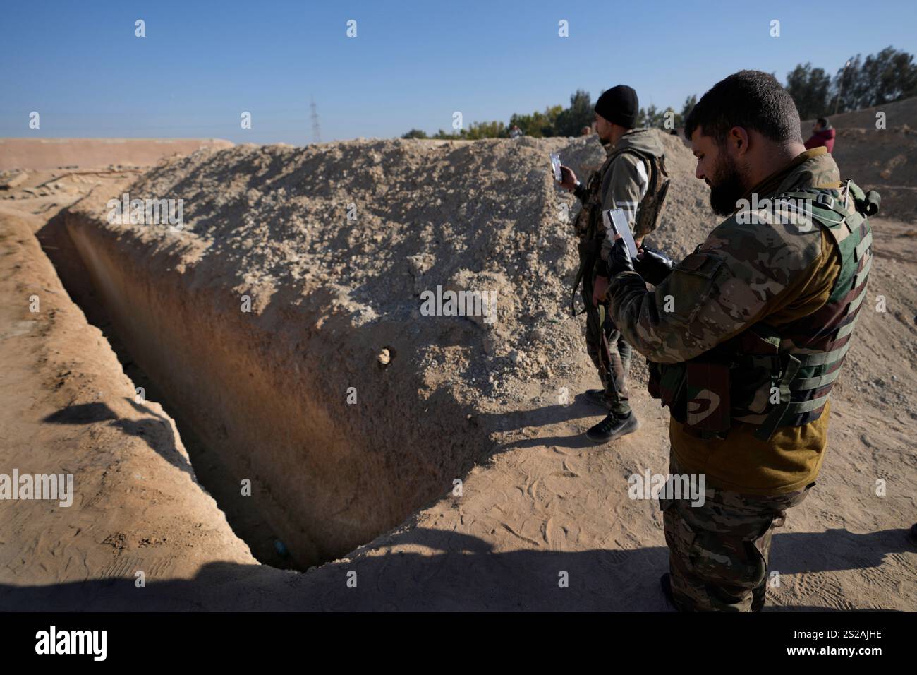 Fighters who helped oust former Syrian ruler Bashar Assad examine a ...