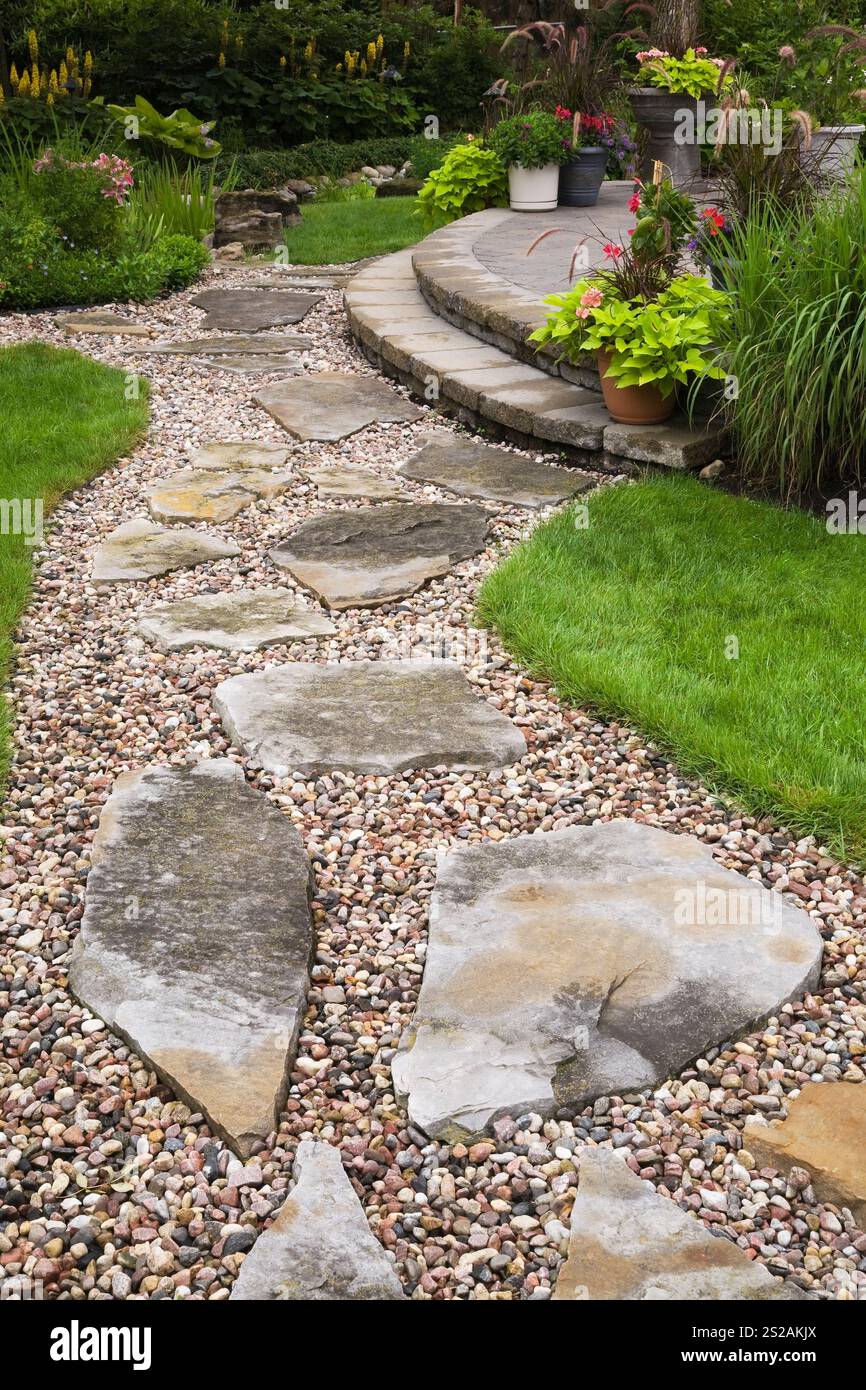 Flagstone and gravel path through manicured green grass lawn leading to ...