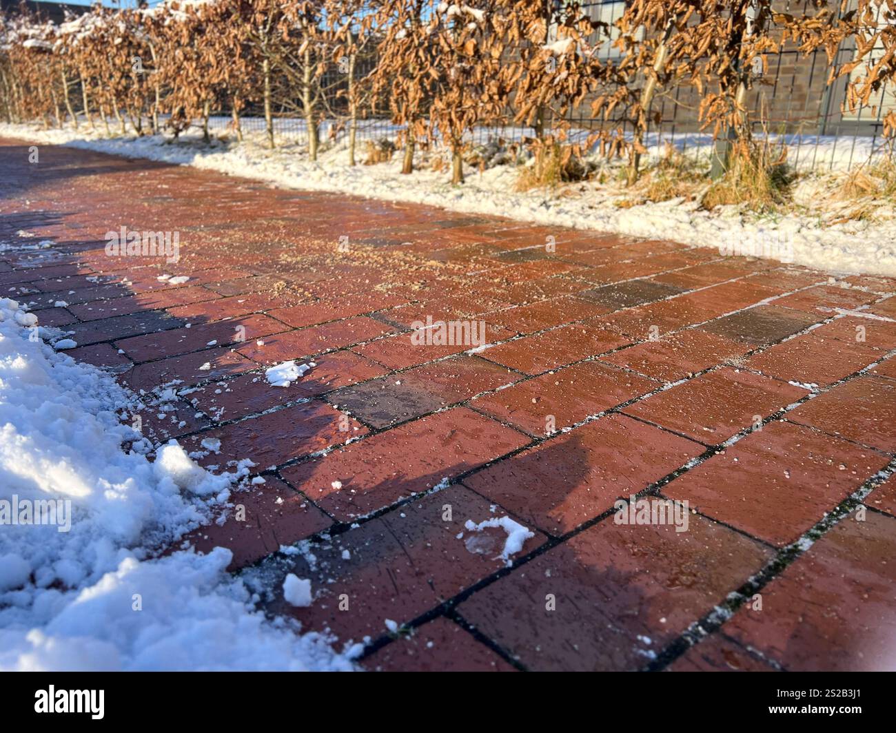 An icy pedestrian path sidewalk in winter with snow and sand Stock ...