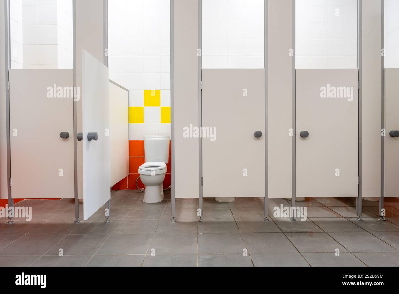 Clean public restroom with separate stalls and colorful wall design in ...