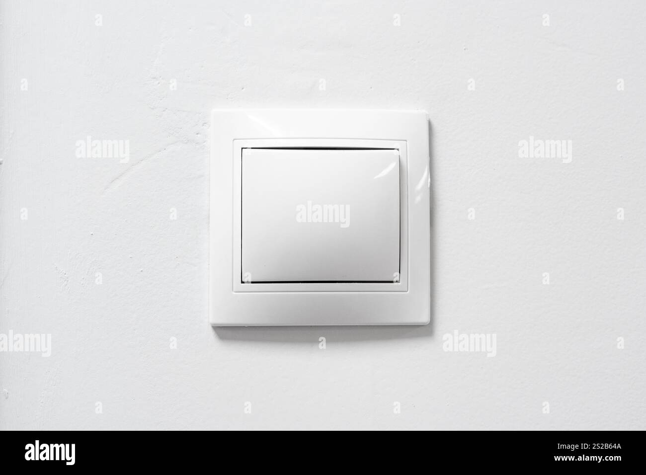 White light switch on a plain wall, designed for easy access and modern ...