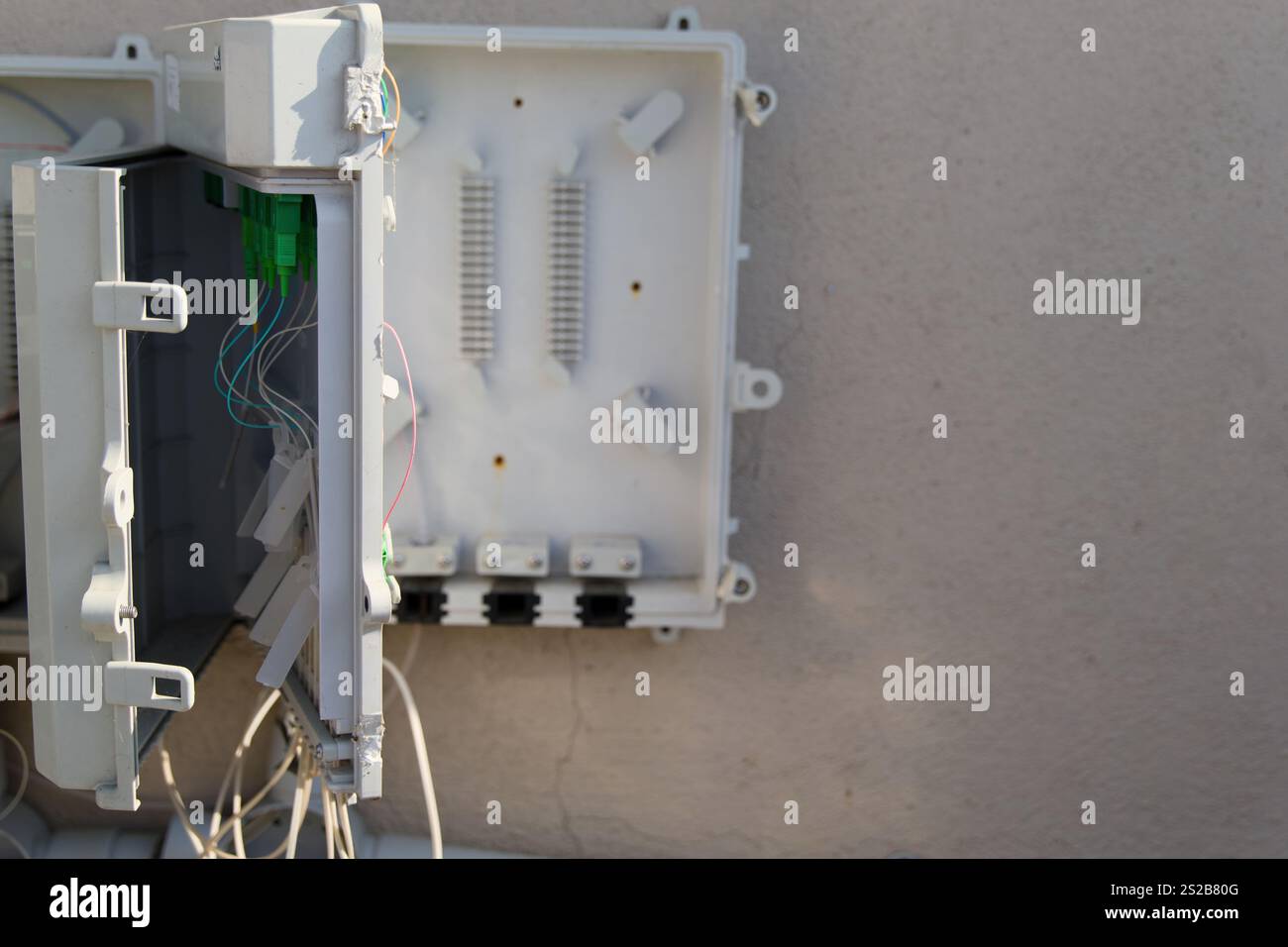 A utility box is open, revealing various networking components and ...