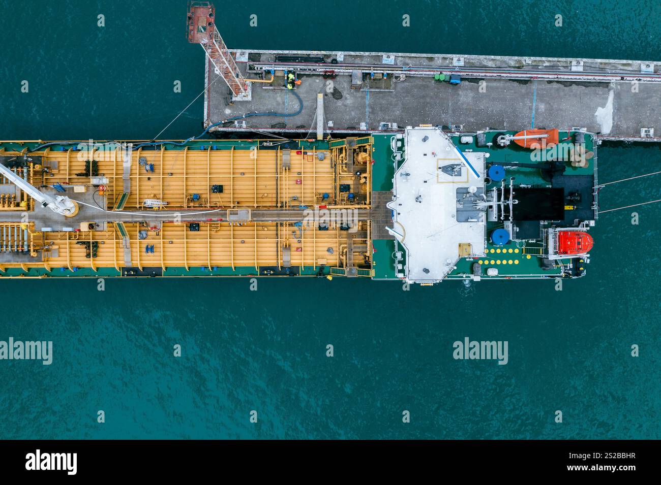 Top-down aerial shot of large oil tanker docked at pier, industrial ...