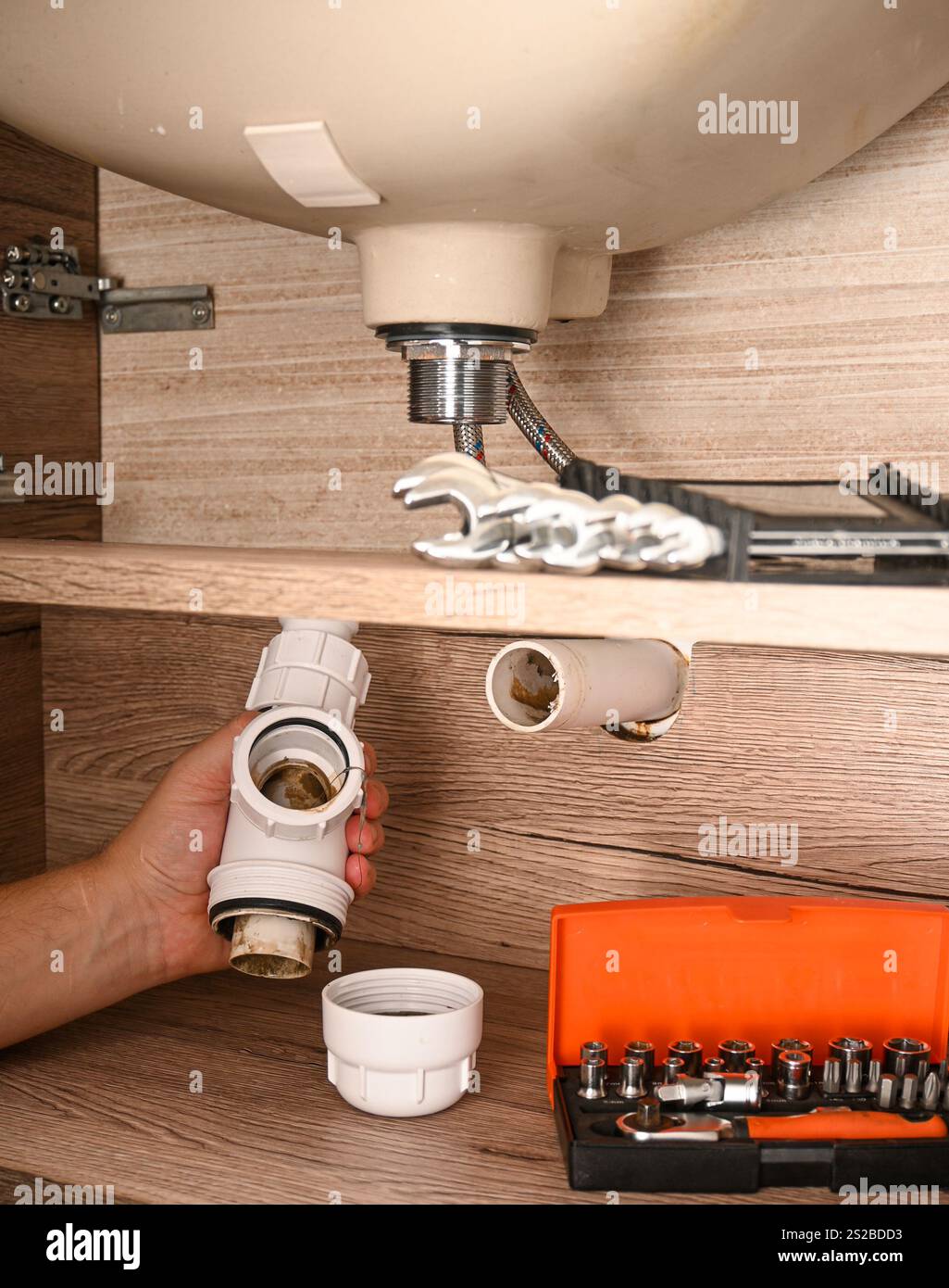 Plumber is removing dirty and clogged siphon from sink drain pipe in ...