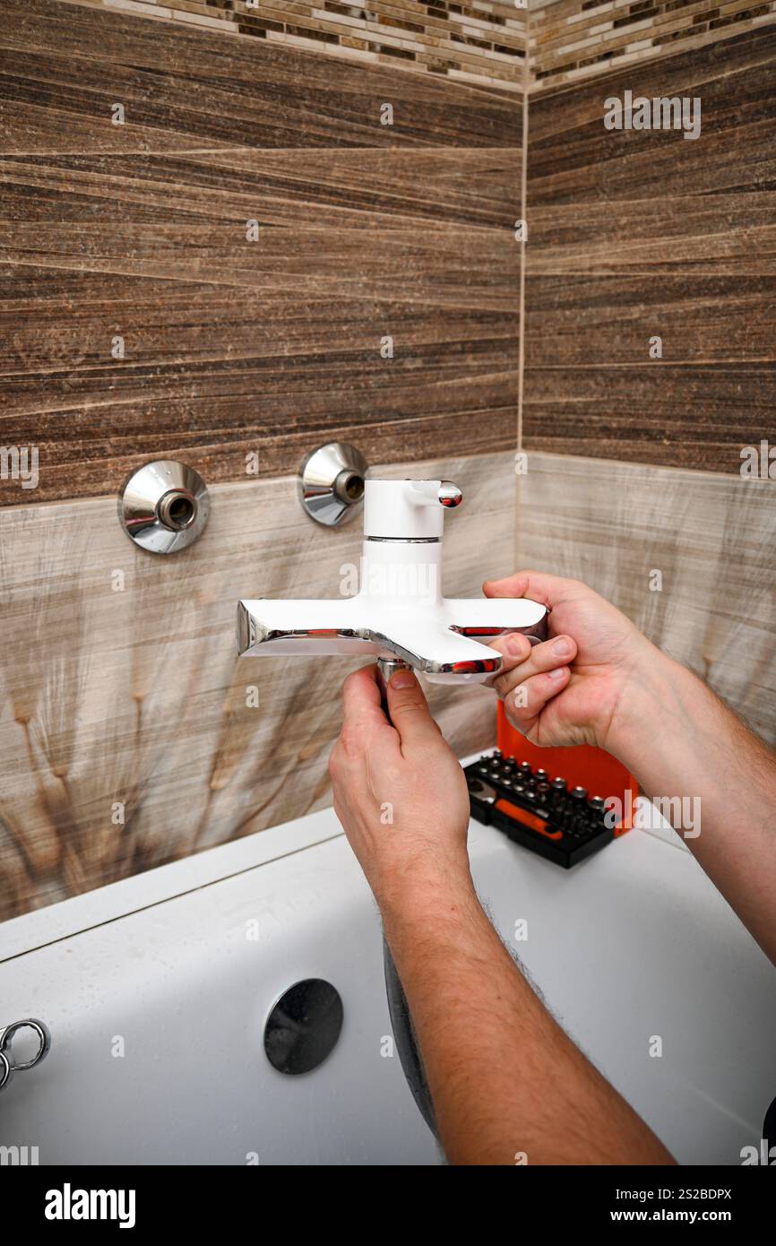 Professional plumber carefully installing hi-res stock photography and ...