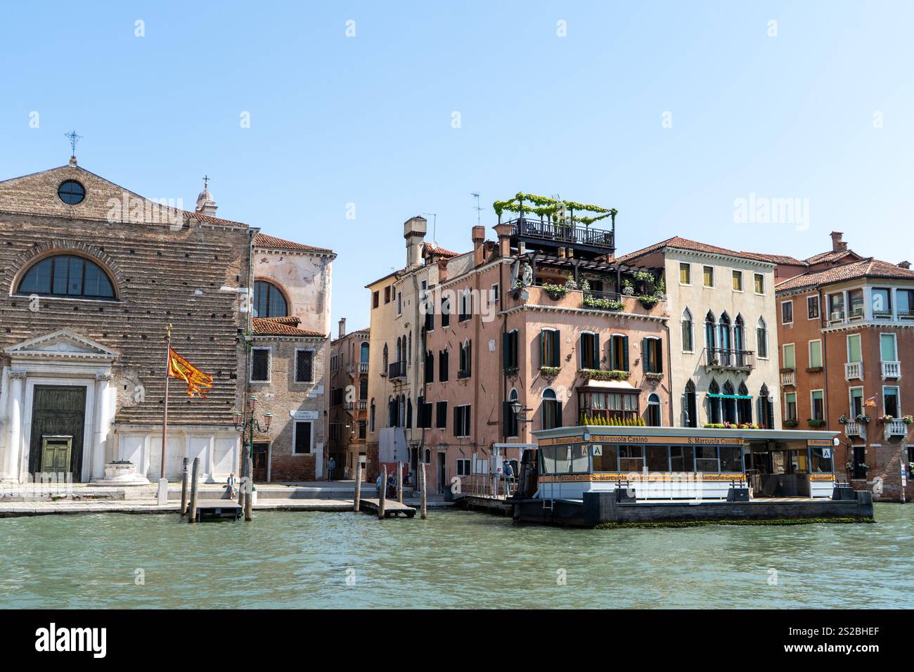 A Venetian waterfront featuring colorful historic buildings, a church ...