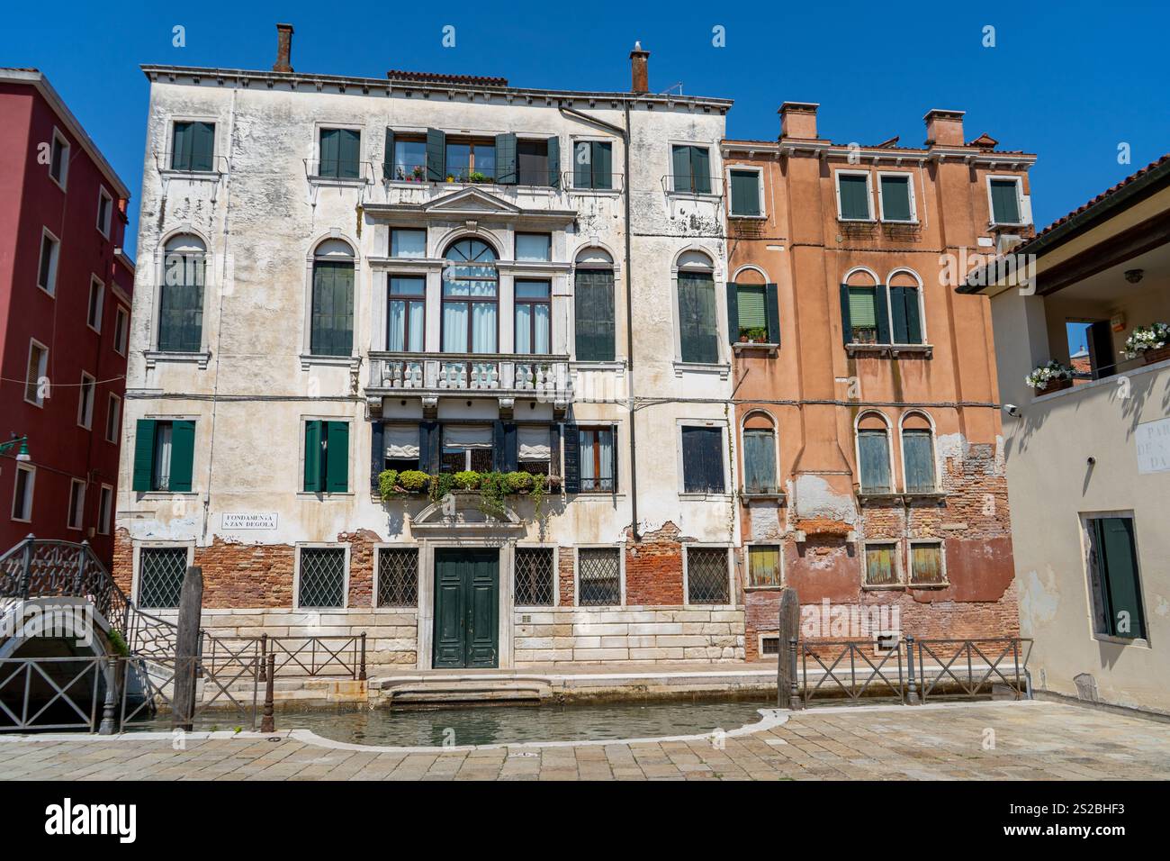 A row of historic Venetian buildings with colorful facades facing a ...