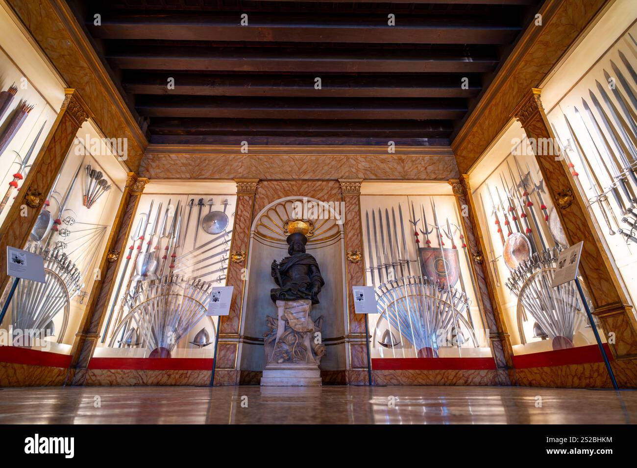 A historic armory room showcasing an array of swords, spears, and ...