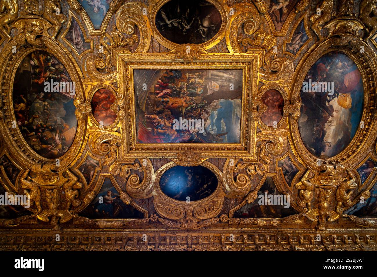 An ornate baroque ceiling featuring intricate gold frames and richly ...