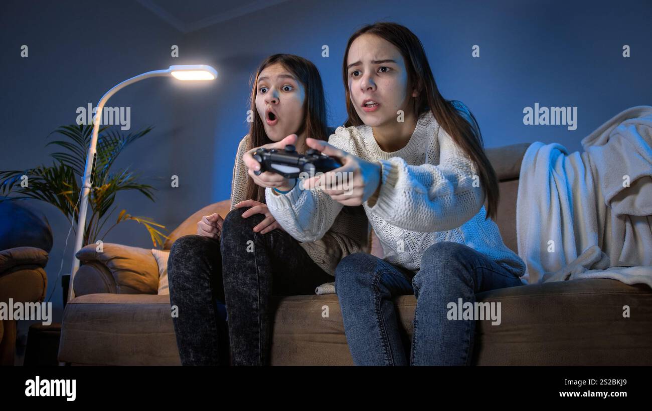 Happy laughing girls celebrating after victory in video game on console ...