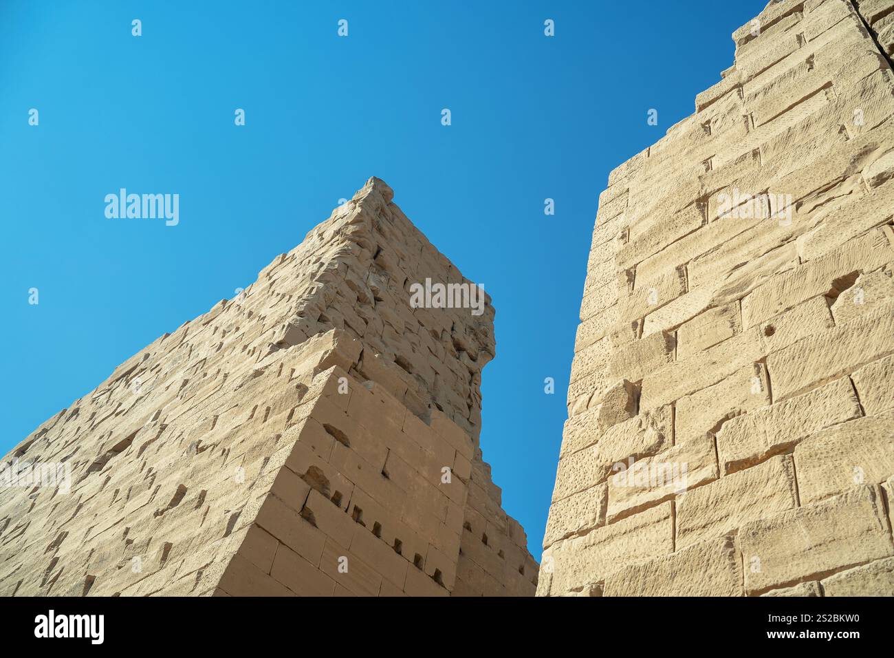 Ancient Egyptian brick block wall in luxor against blue sky Stock Photo ...