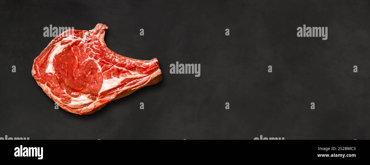 Raw beef prime rib isolated on black concrete background. Top view ...