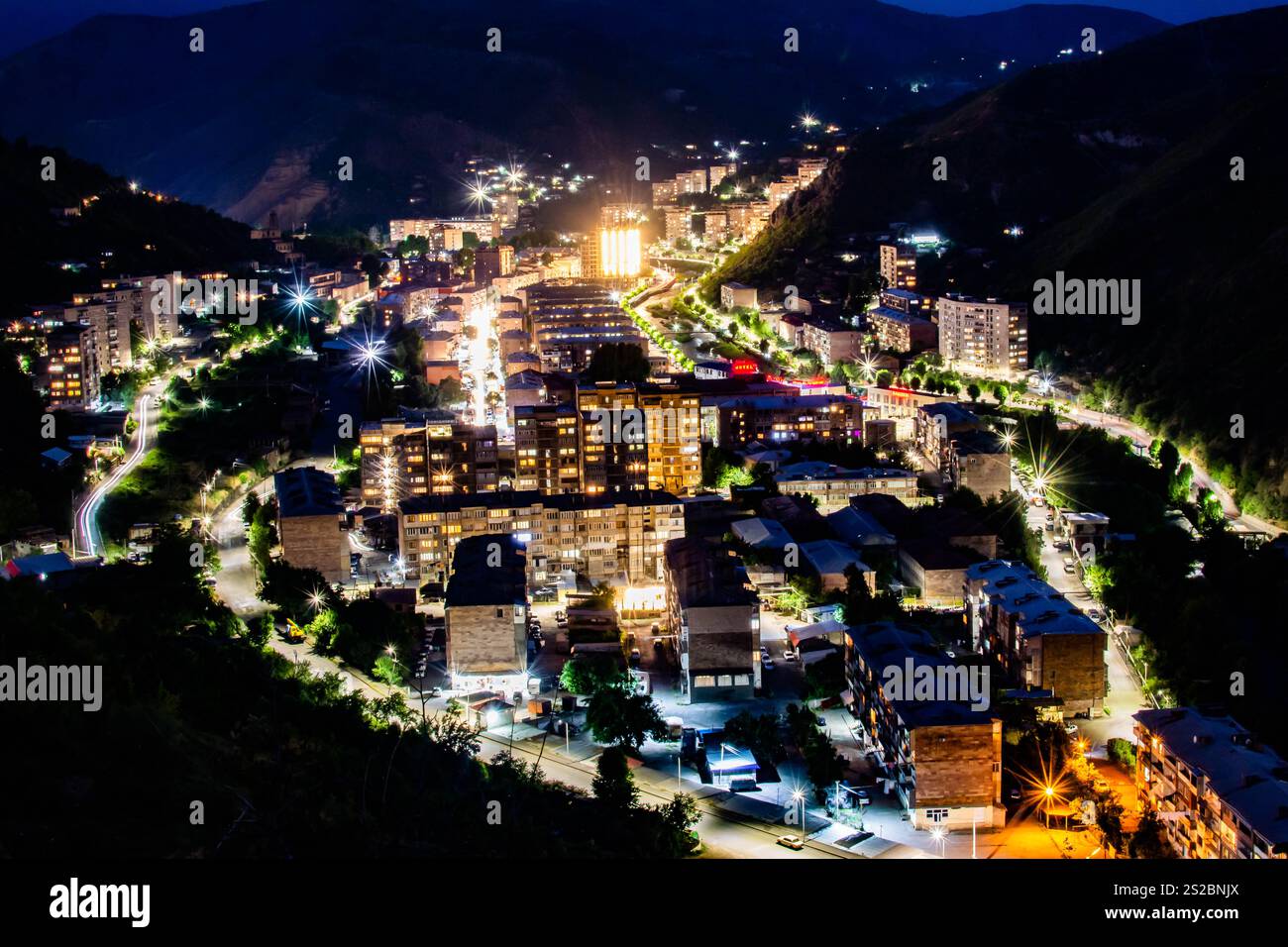 Night city life. Lights of buildings. Cars traffic lights. River over ...