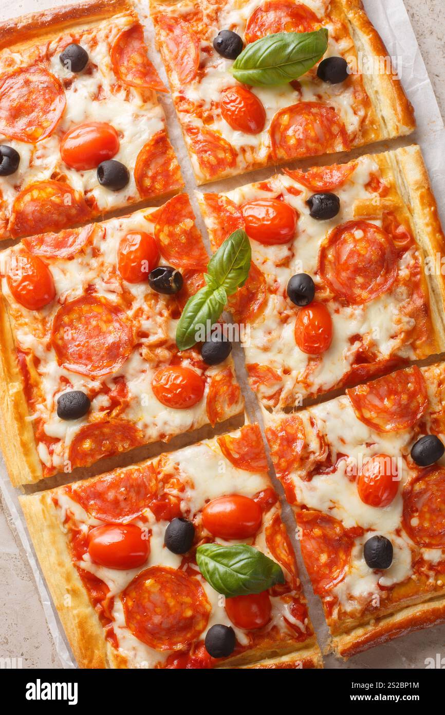 Puff pastry pizza with pepperoni sausage, olives, tomatoes and ...