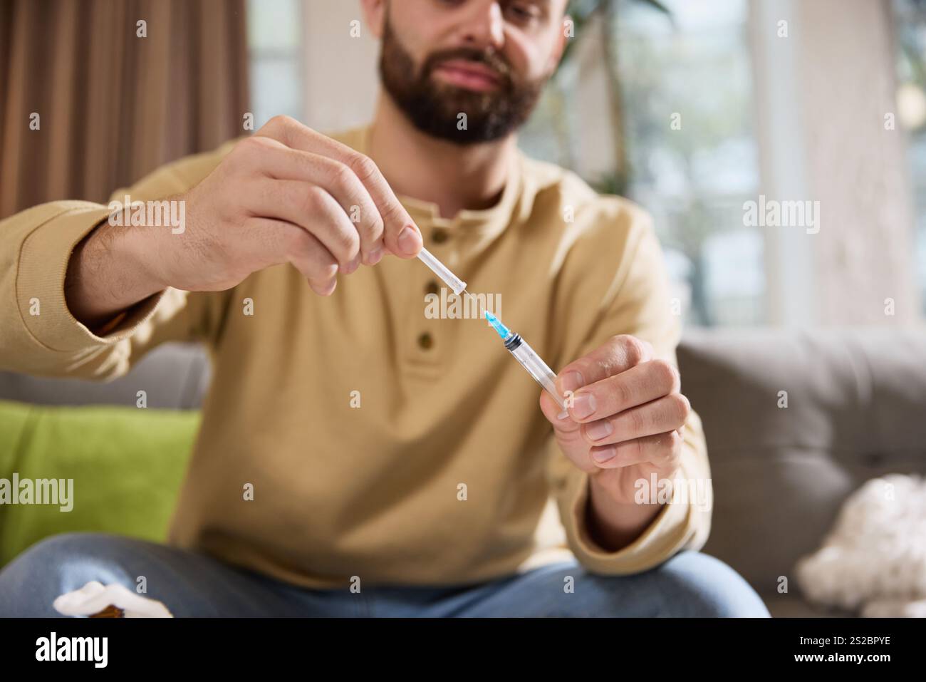 Close of male model holding medicine and clean, disinfected syringe ...