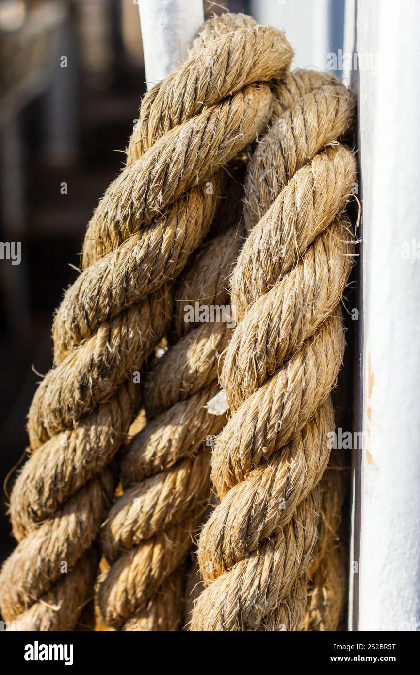 A detailed close-up image of thick, textured fiber rope securely tied ...