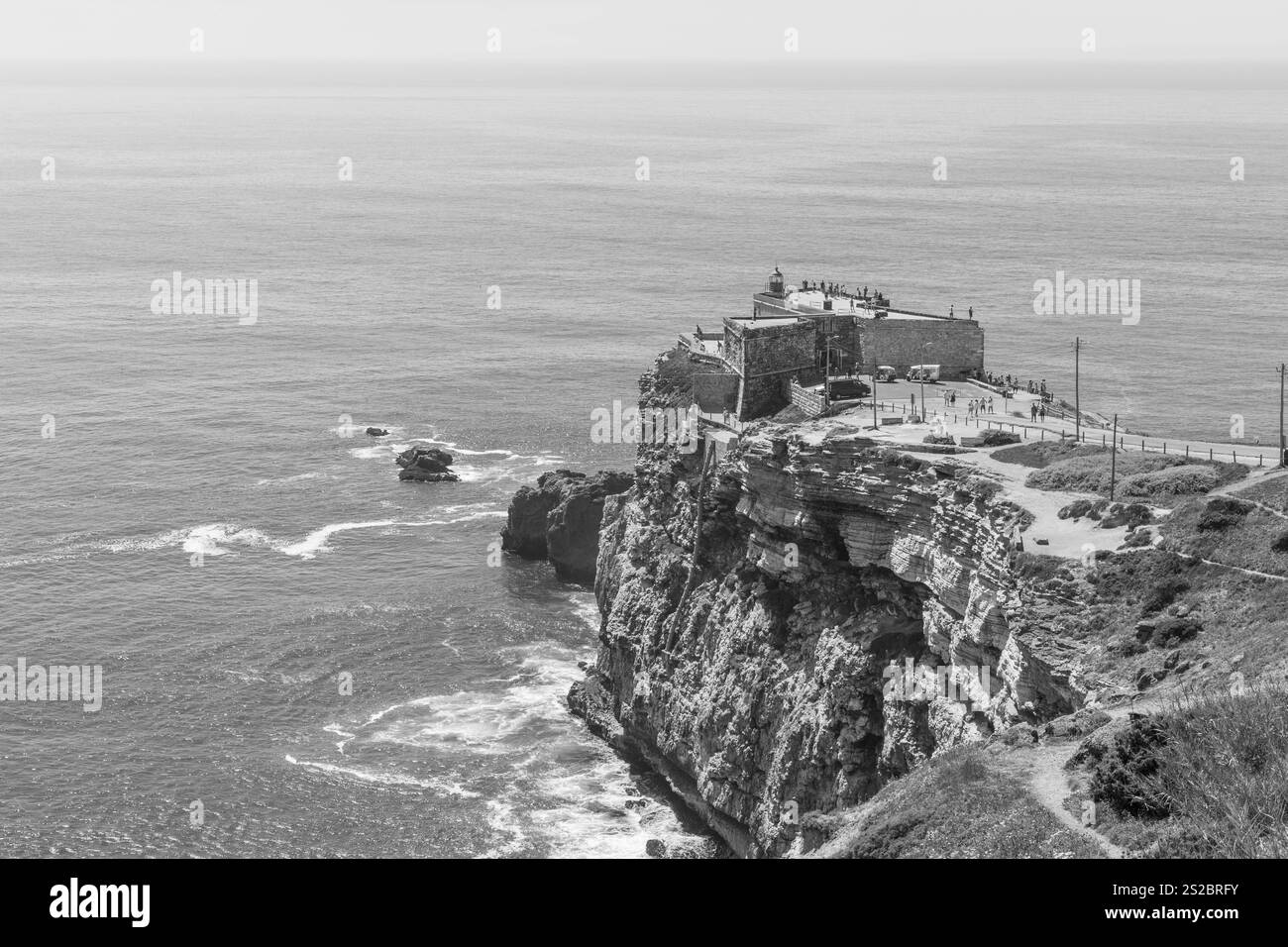 Black and white Fort of Sao Miguel Arcanjo on a cliff in Nazare ...