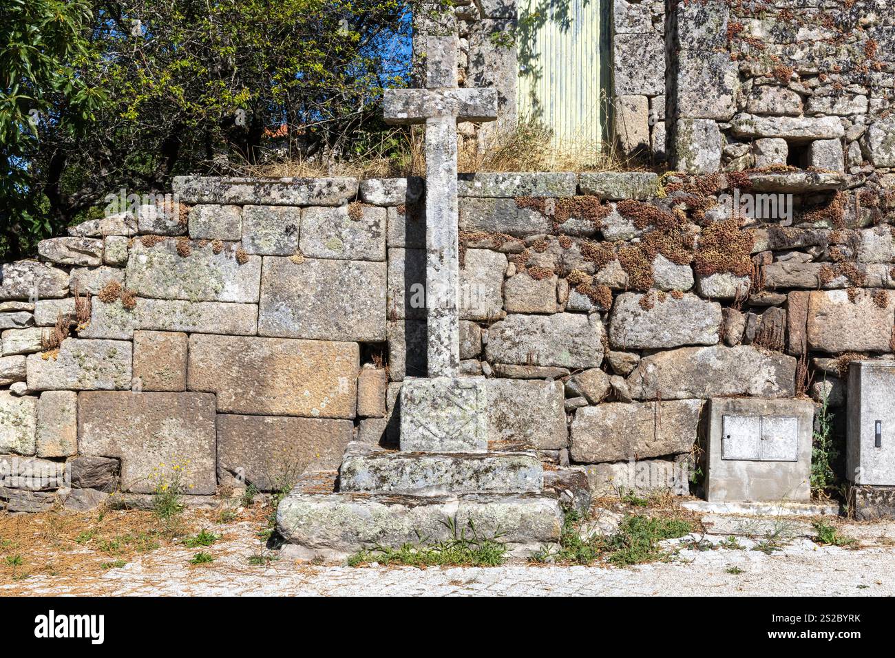 Religious granite christianity cross in font of granite wall with moss ...
