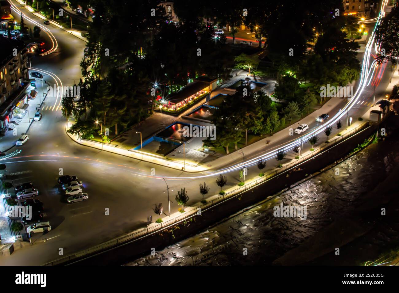 Night city life. Lights of buildings. Cars traffic lights. River over ...