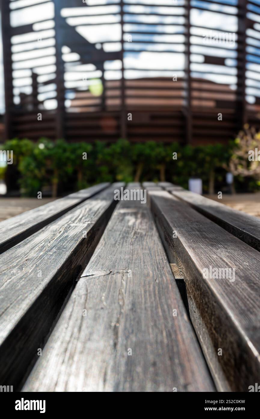 A bench with a view of a building. The bench is made of wood and is ...