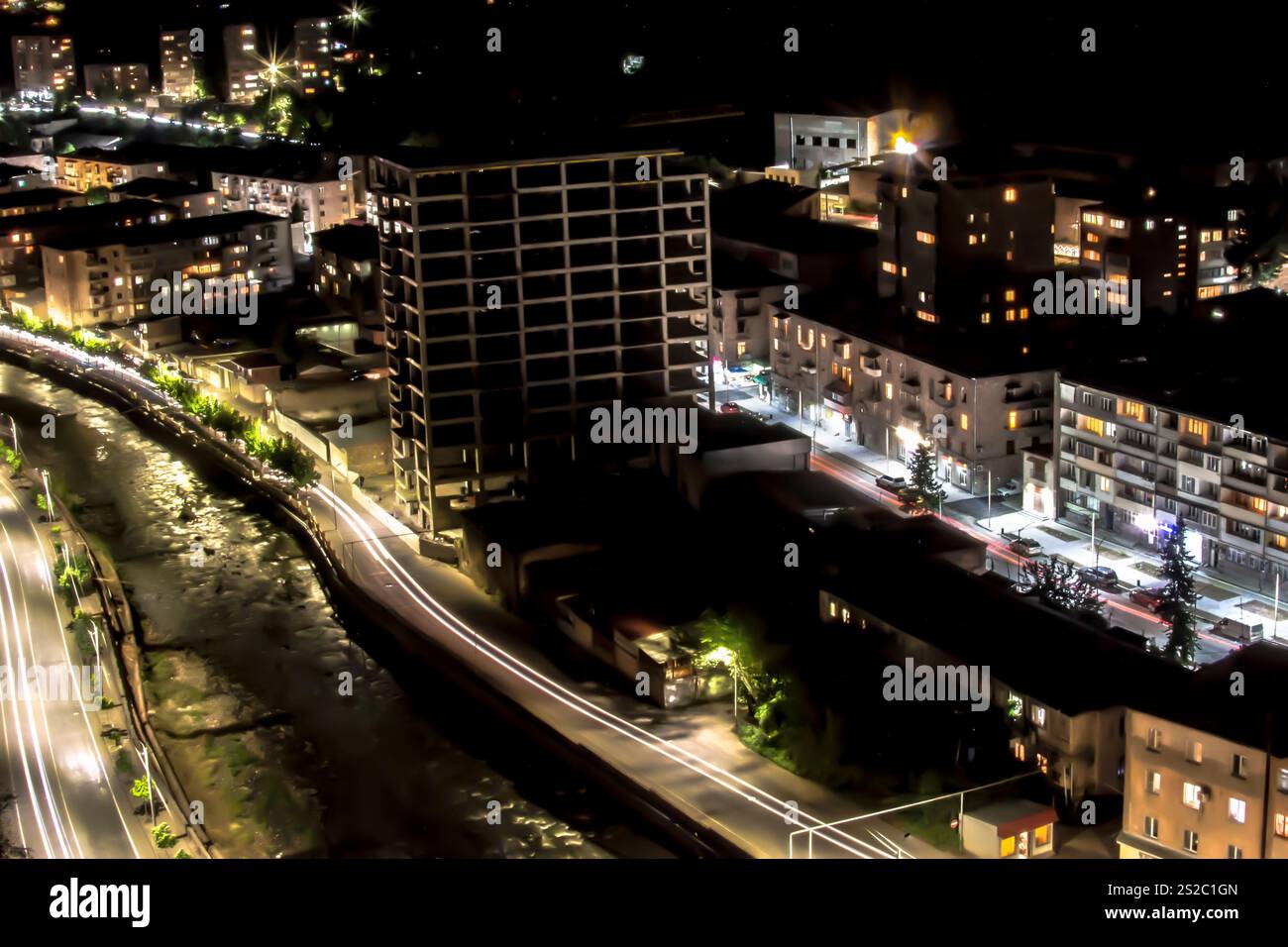 Night city life. Lights of buildings. Cars traffic lights. River over ...