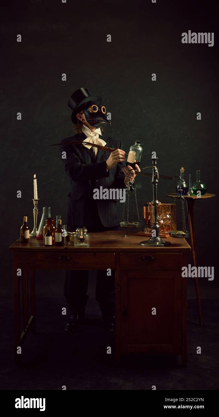 Plague doctor working under candlelight in vintage laboratory with ...